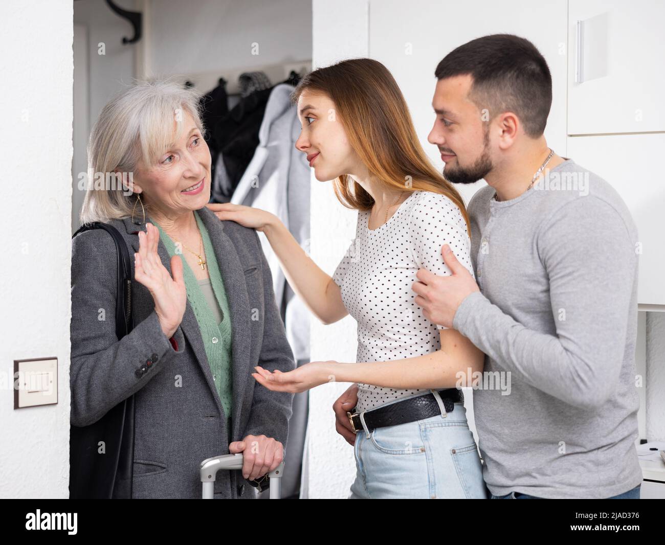 Young family couple seeing off mature woman Stock Photo - Alamy