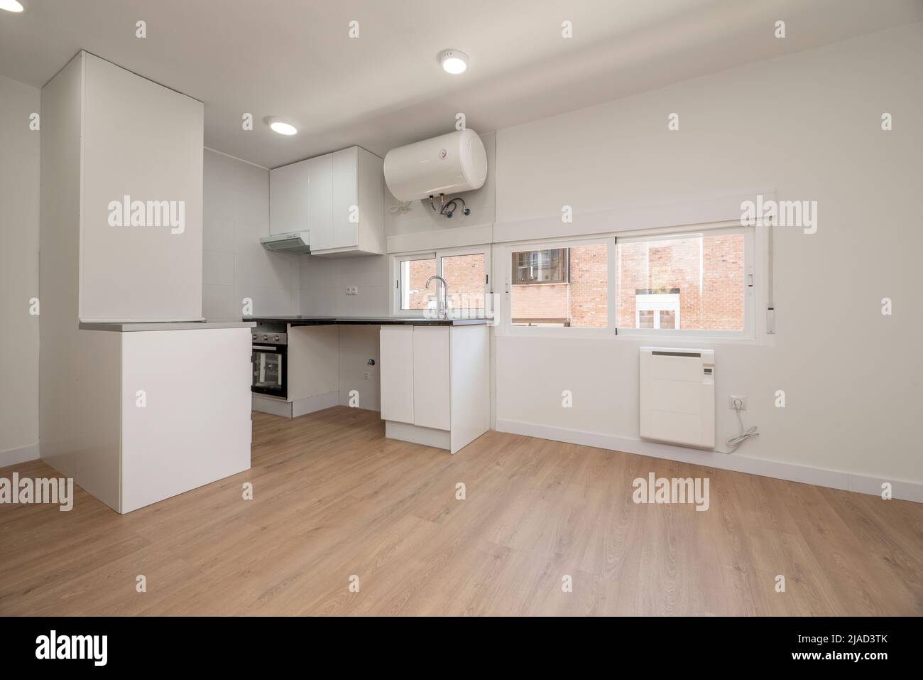 Newly fitted kitchen with shiny black worktop awaiting the washing ...