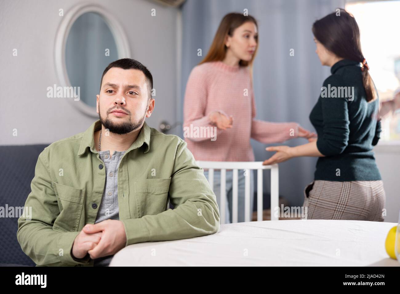 Man waiting for two women stop quarreling Stock Photo - Alamy