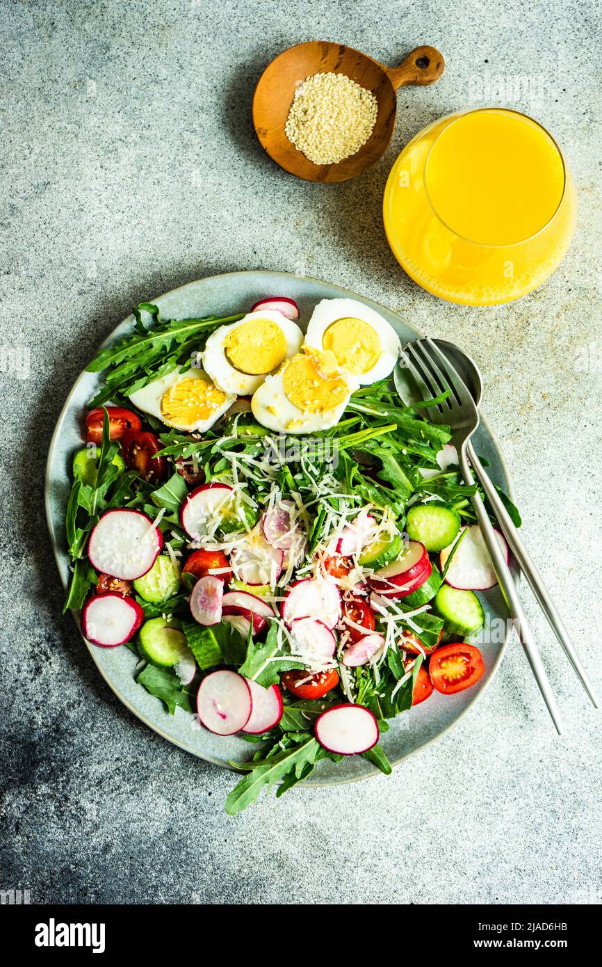 Overhead view of a salad with rocket, cucumber, cherry tomatoes, radish ...