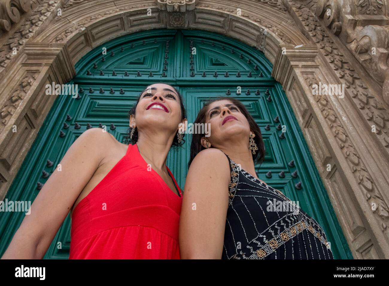 Portrait of two women wearing Venice Carnival mask against a church ...