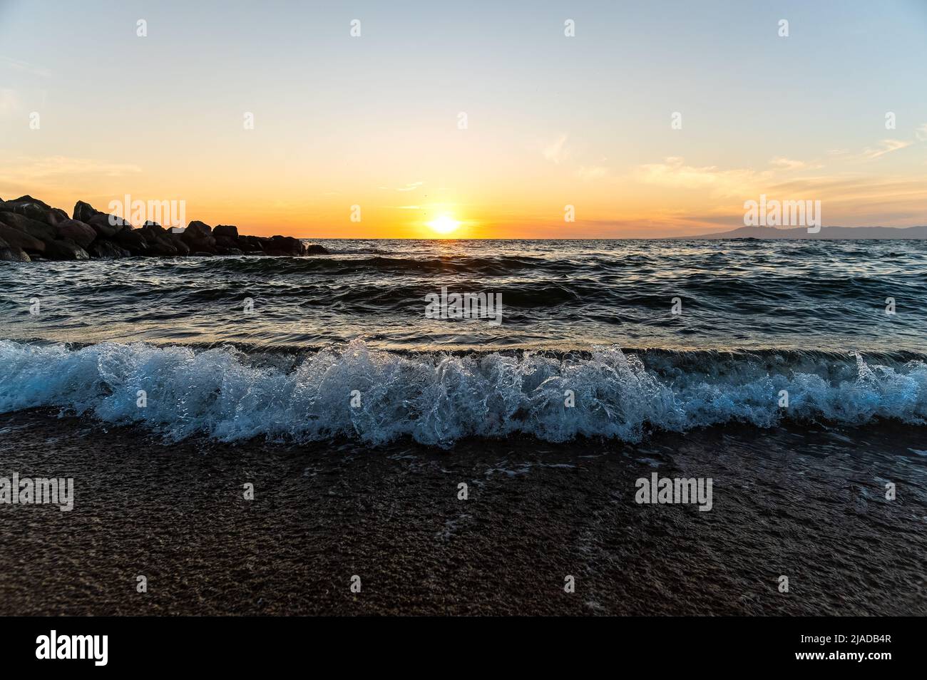 A Beautiful Colorful Ocean Sunset With A Sparkling Wave Breaking On ...
