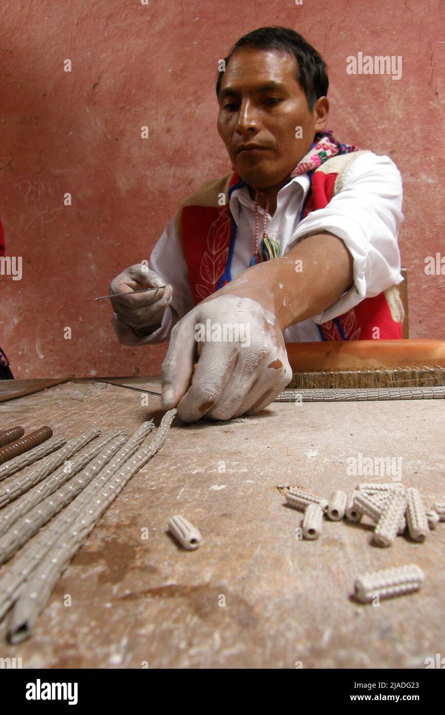 Peruvian peasant craftsmen, making beads and small clay handicrafts ...