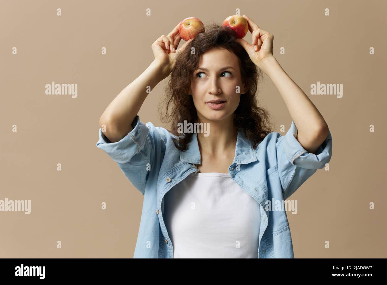 Lovely funny curly beautiful female in jeans casual shirt with apple ...