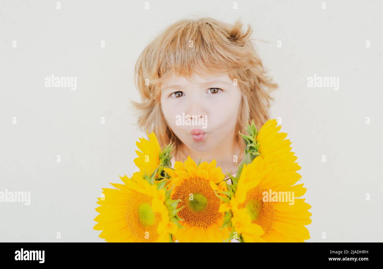 Smiling kid with sunflowers. Happy child with bouquet of flowers. Cute ...
