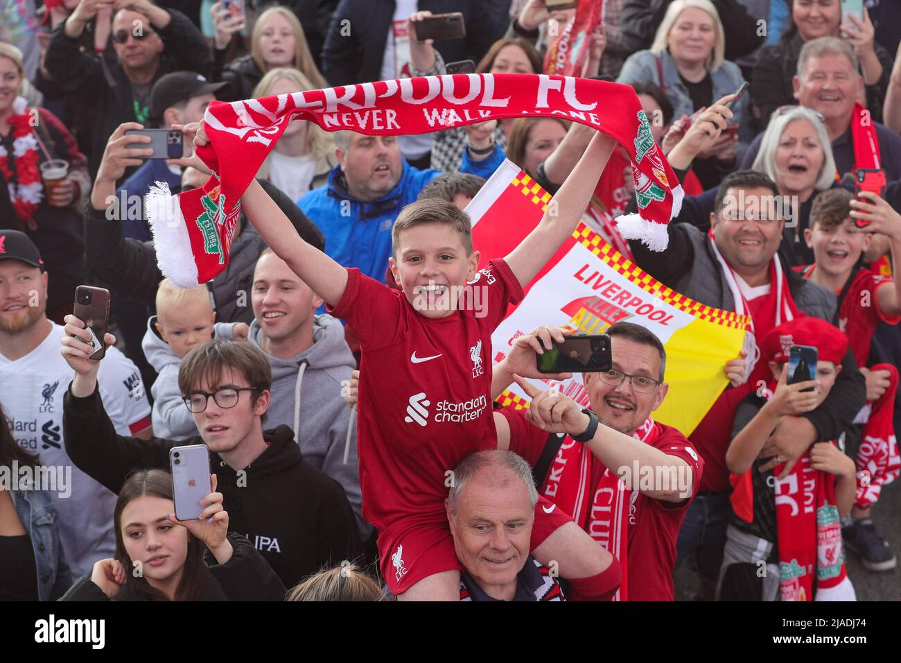 A young Liverpool supporter holds up a scarf as the Liverpool FC squad ...