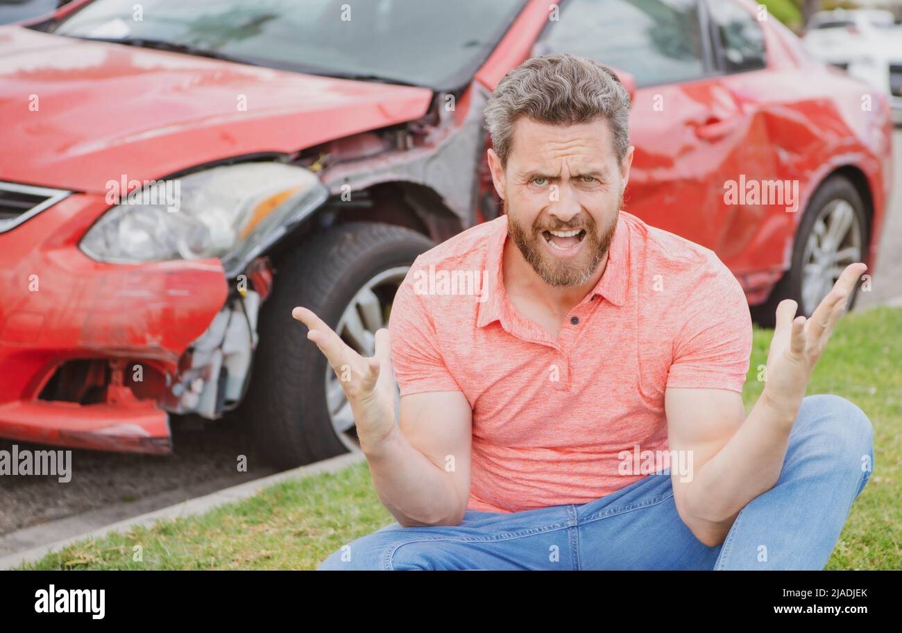 Stressed driver sitting on the road next to broken car Stock Photo - Alamy