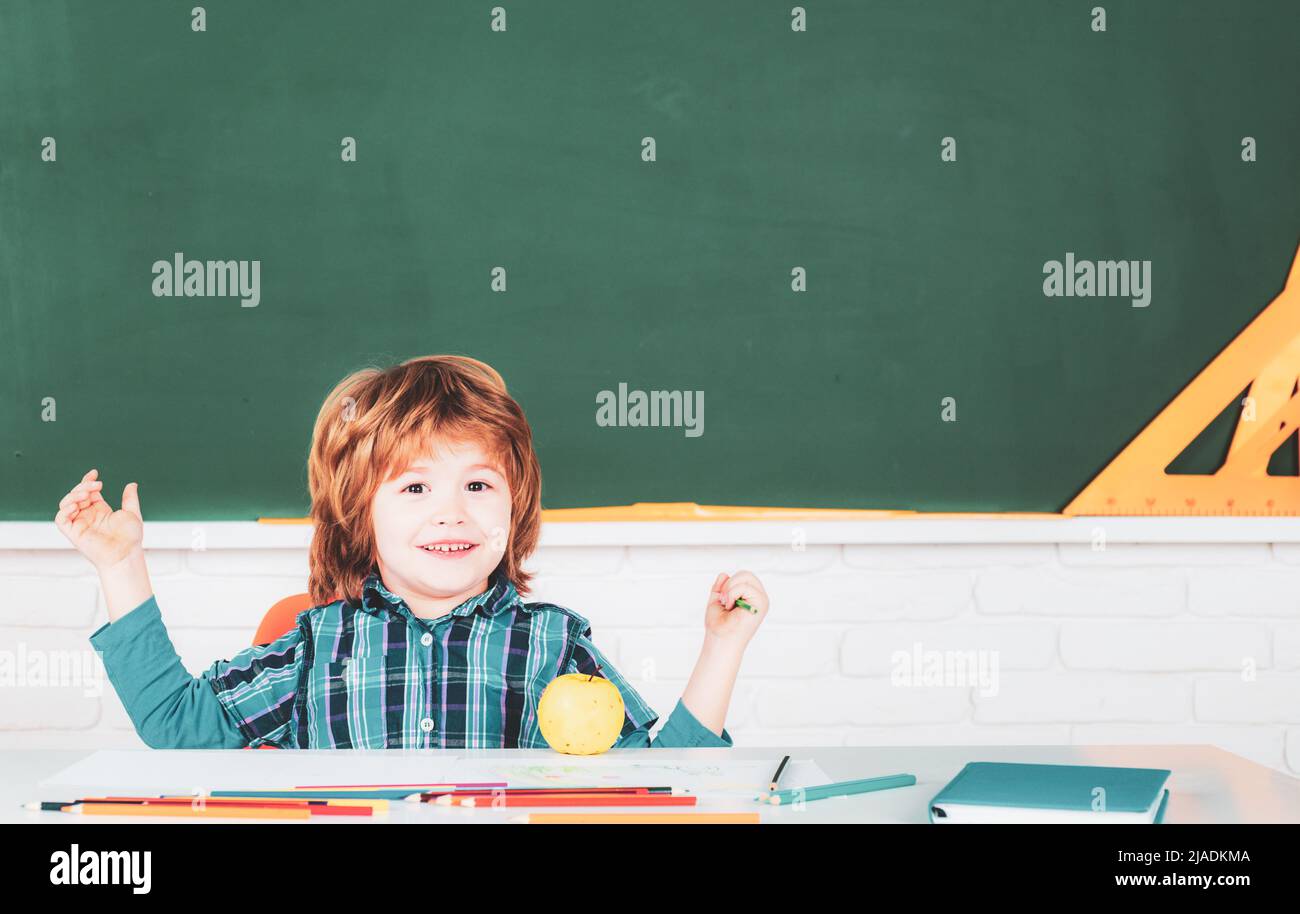 Talented child. Kid is learning in class on background of blackboard ...