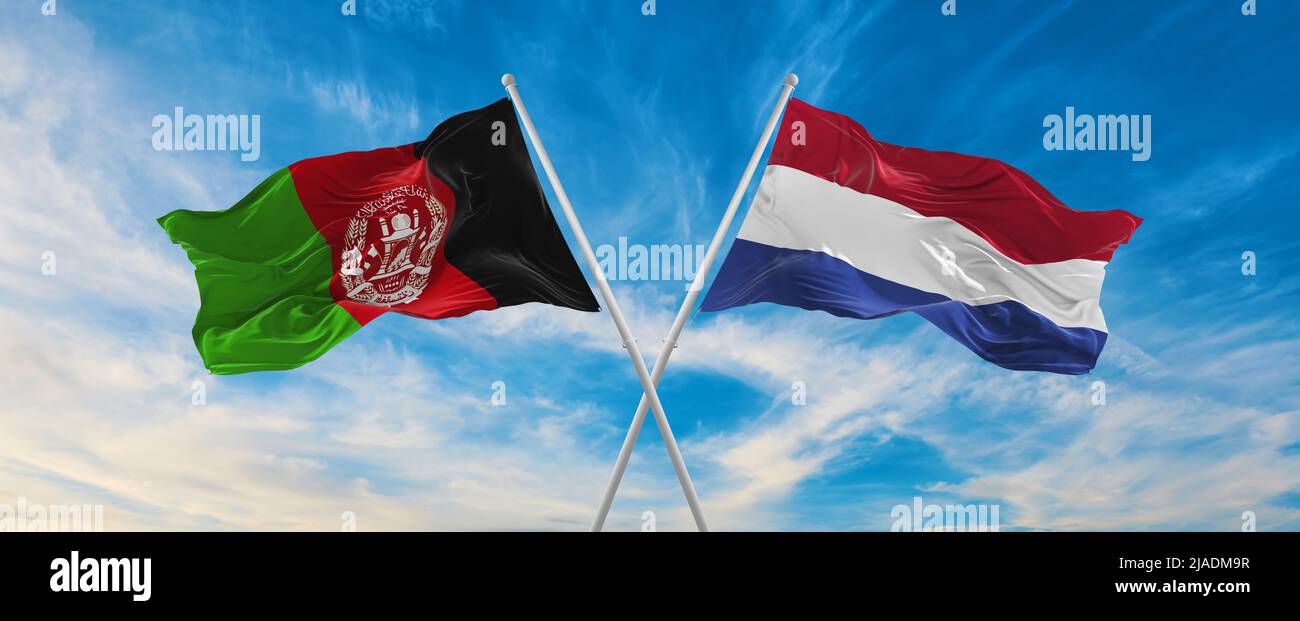 two crossed flags Afghanistan and Netherland waving in wind at cloudy sky. Concept of ...