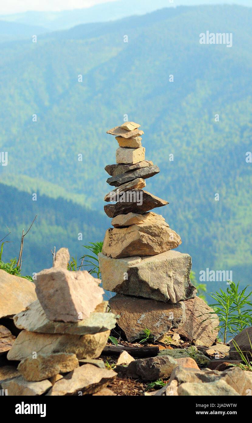 Small stone pyramids on top of a hill overlooking mountains overgrown ...