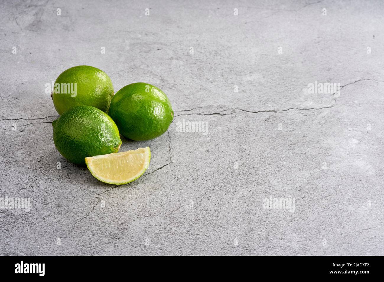 Three limes with slice on kitchen counter Stock Photo - Alamy