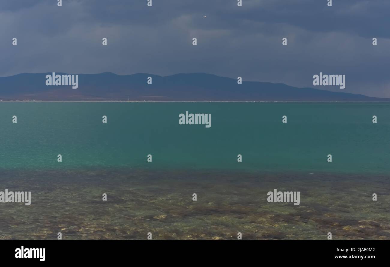 Dark blue clouds and sea or ocean water surface with dramatic seascape ...