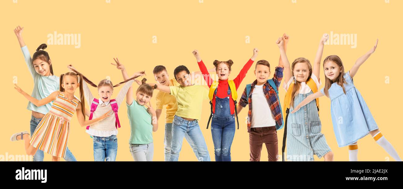 Group of happy little children on yellow background Stock Photo - Alamy