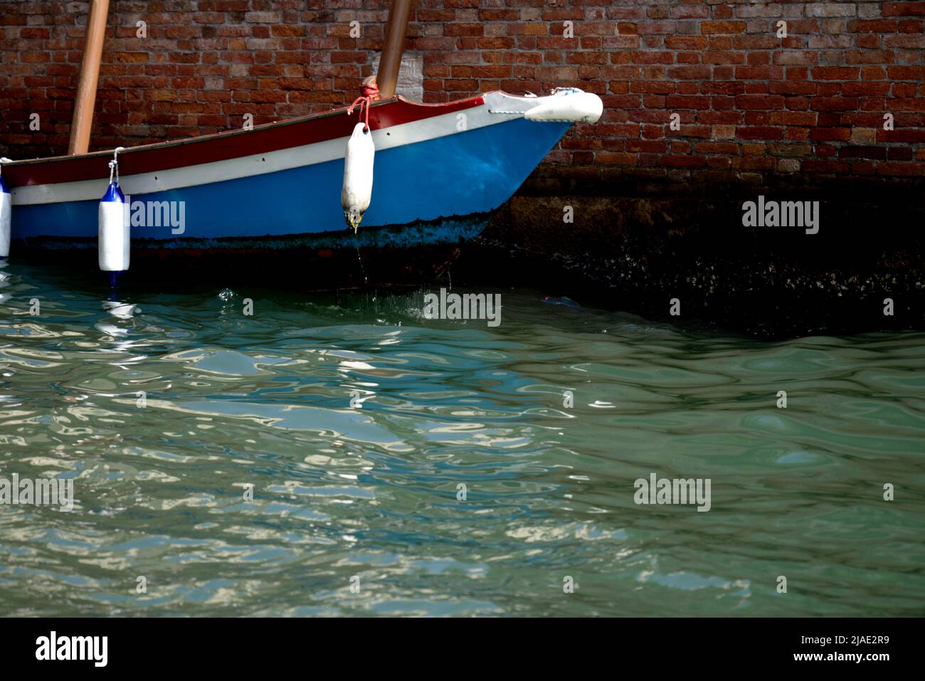 Color, old boat floating in front of a brick wall Stock Photo - Alamy