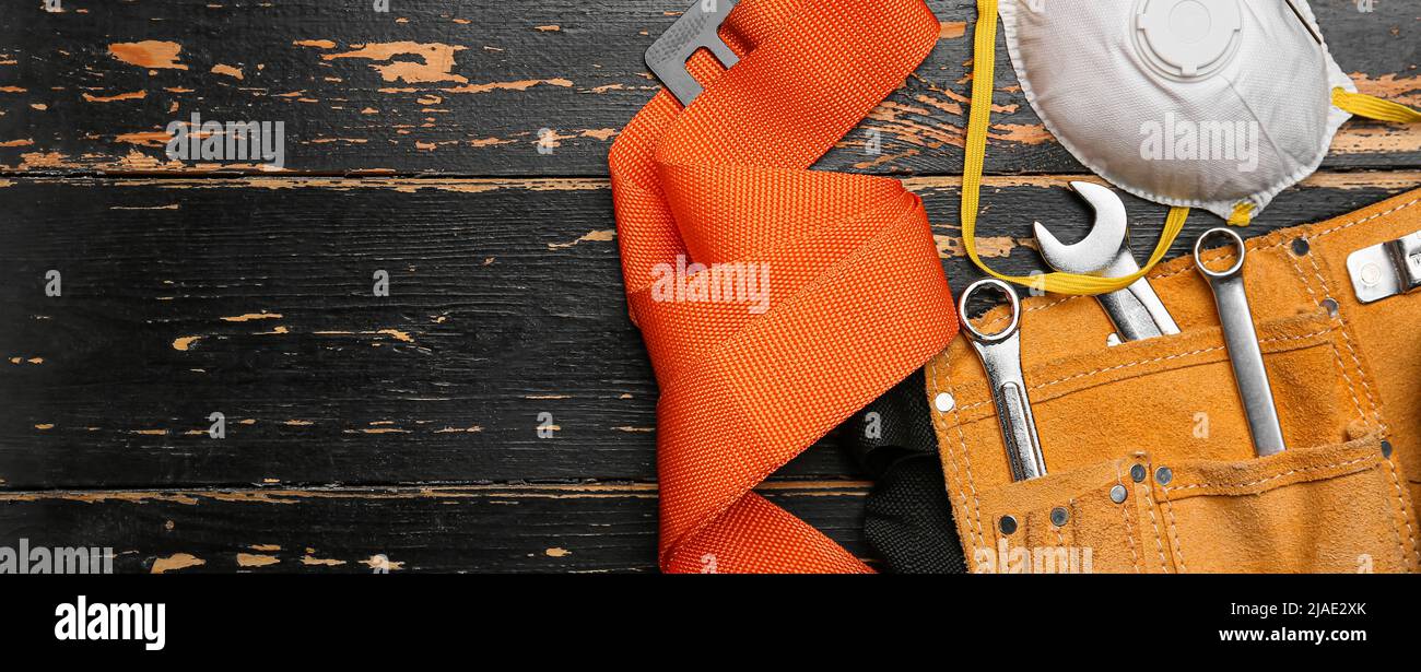 Set of construction tools and equipment on black wooden background with ...