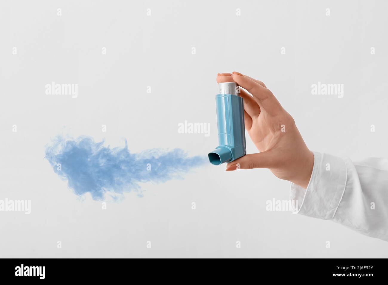 Female hand with inhaler on light background Stock Photo - Alamy