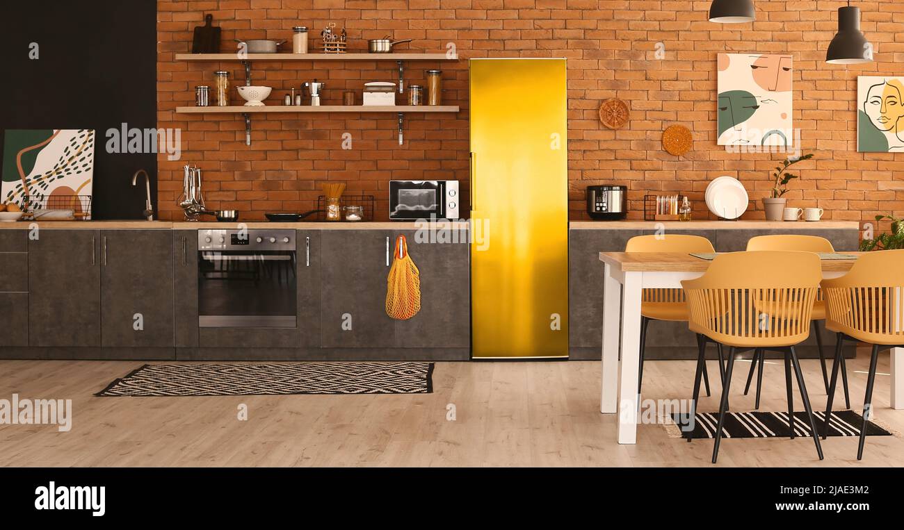 Stylish interior of modern kitchen with yellow fridge and brick wall ...