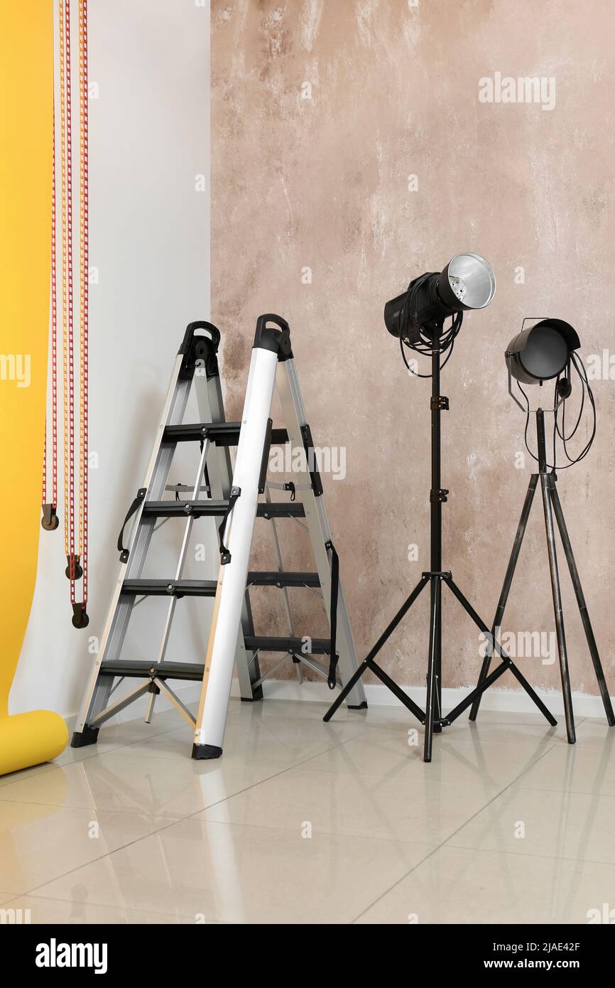 Lighting equipment and ladder in modern photo studio Stock Photo - Alamy