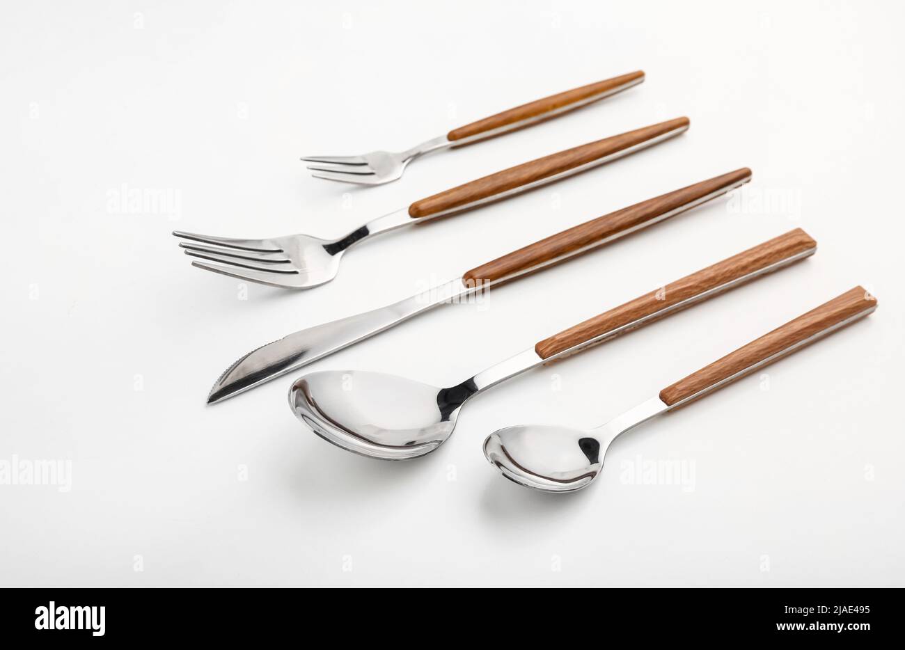Set of stainless steel cutlery with wooden handle on white background ...