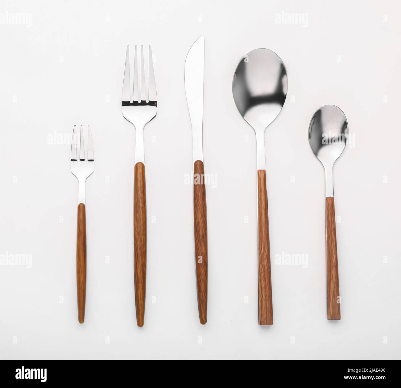 Set of stainless steel cutlery with wooden handle on white background ...