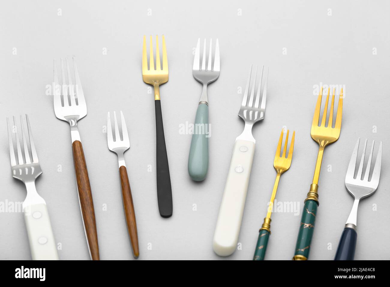 Different forks on light background Stock Photo - Alamy