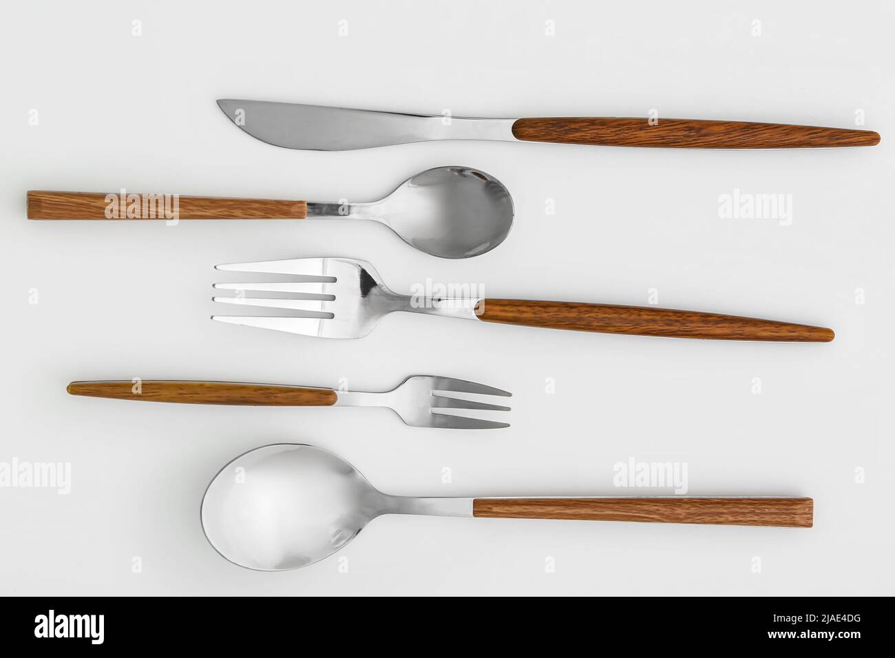 Set of stainless steel cutlery with wooden handle on white background ...