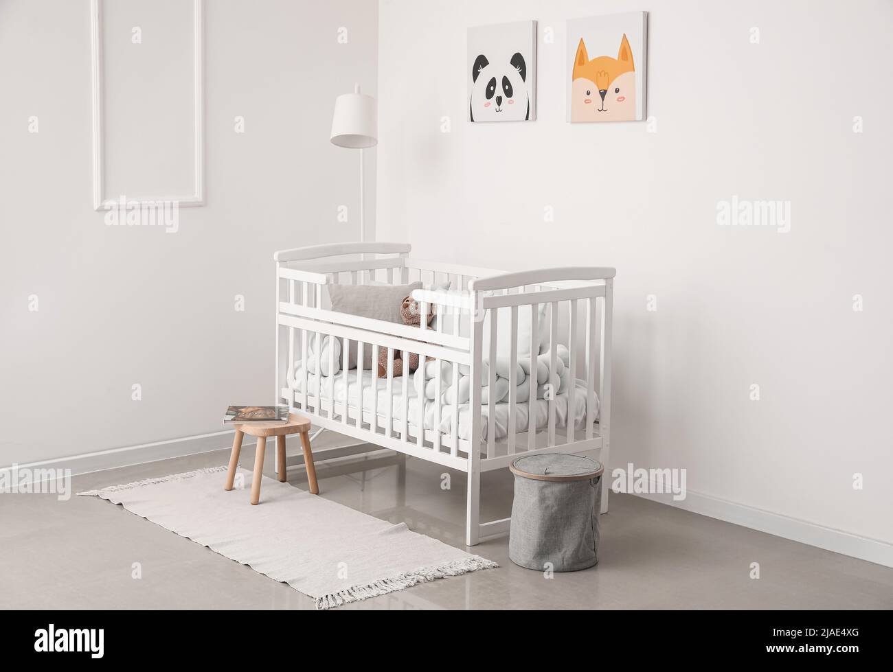 Interior of light nursery with baby crib, lamp and stool Stock Photo ...