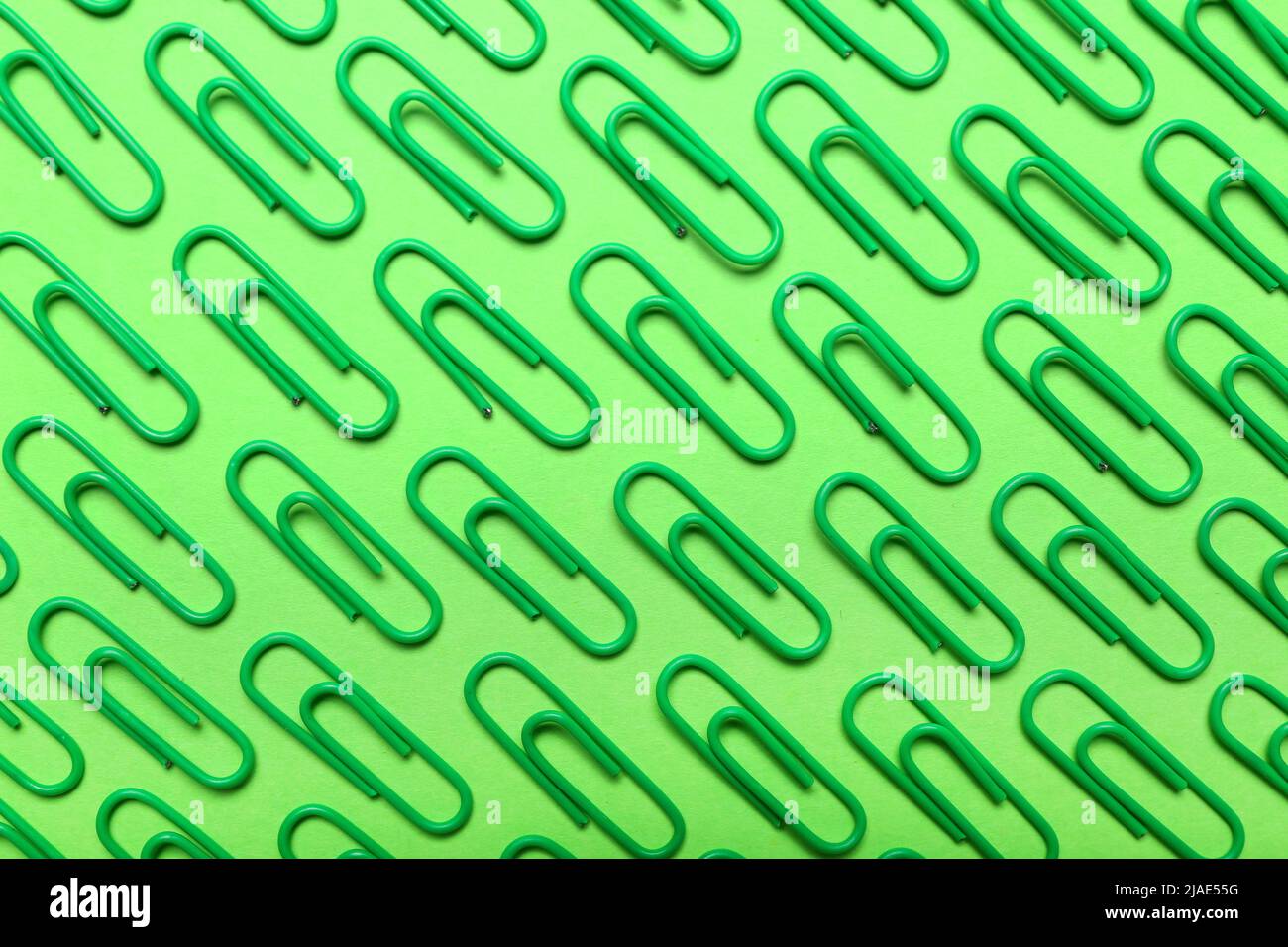 Green paper clips on color background Stock Photo - Alamy