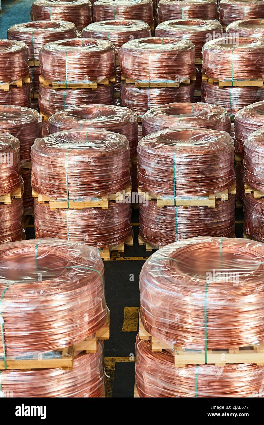 Rows of wrapped copper cable coils in light plant warehouse Stock Photo ...