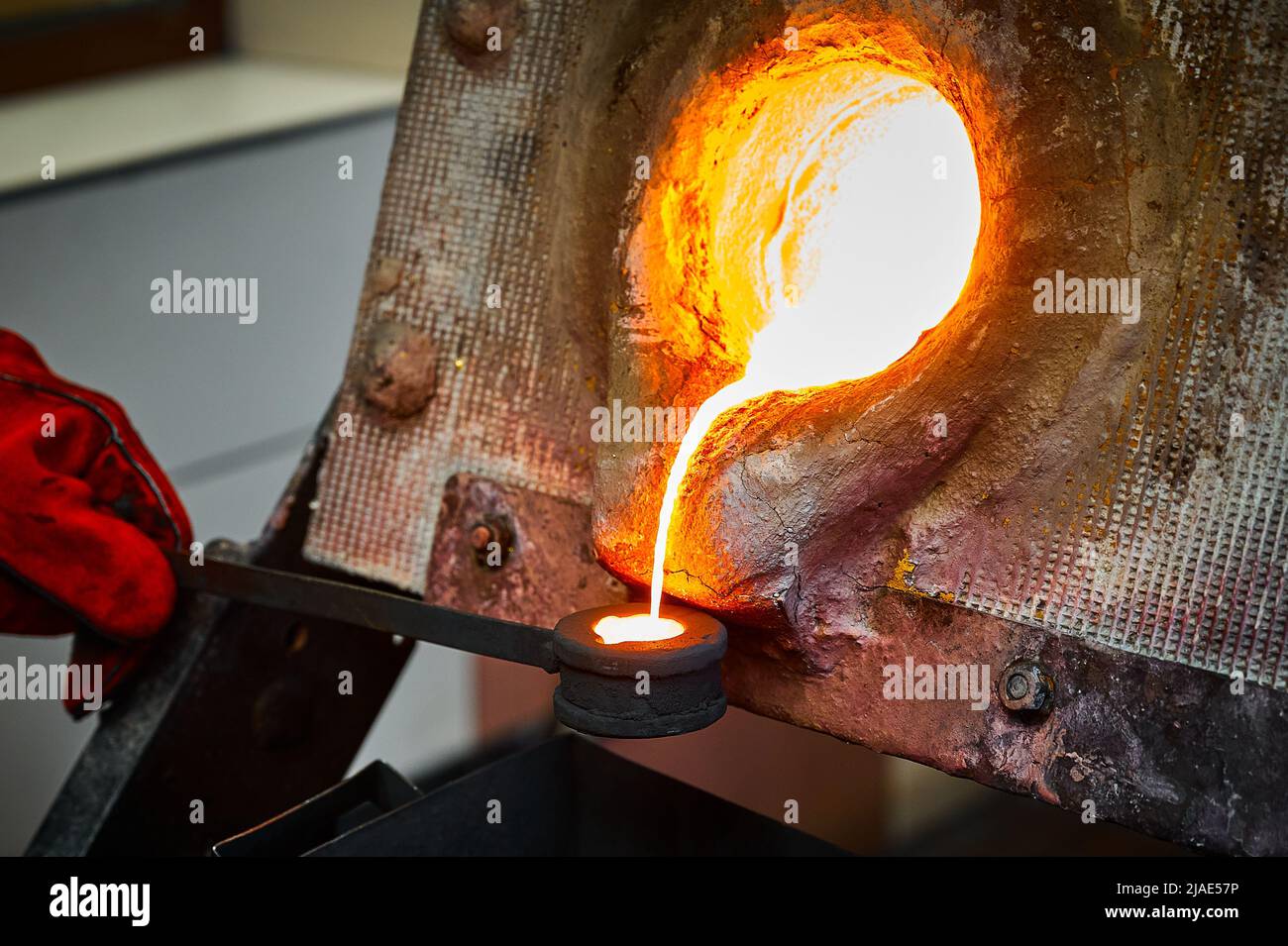 Worker takes sample of liquid gold from furnace for tests Stock Photo ...