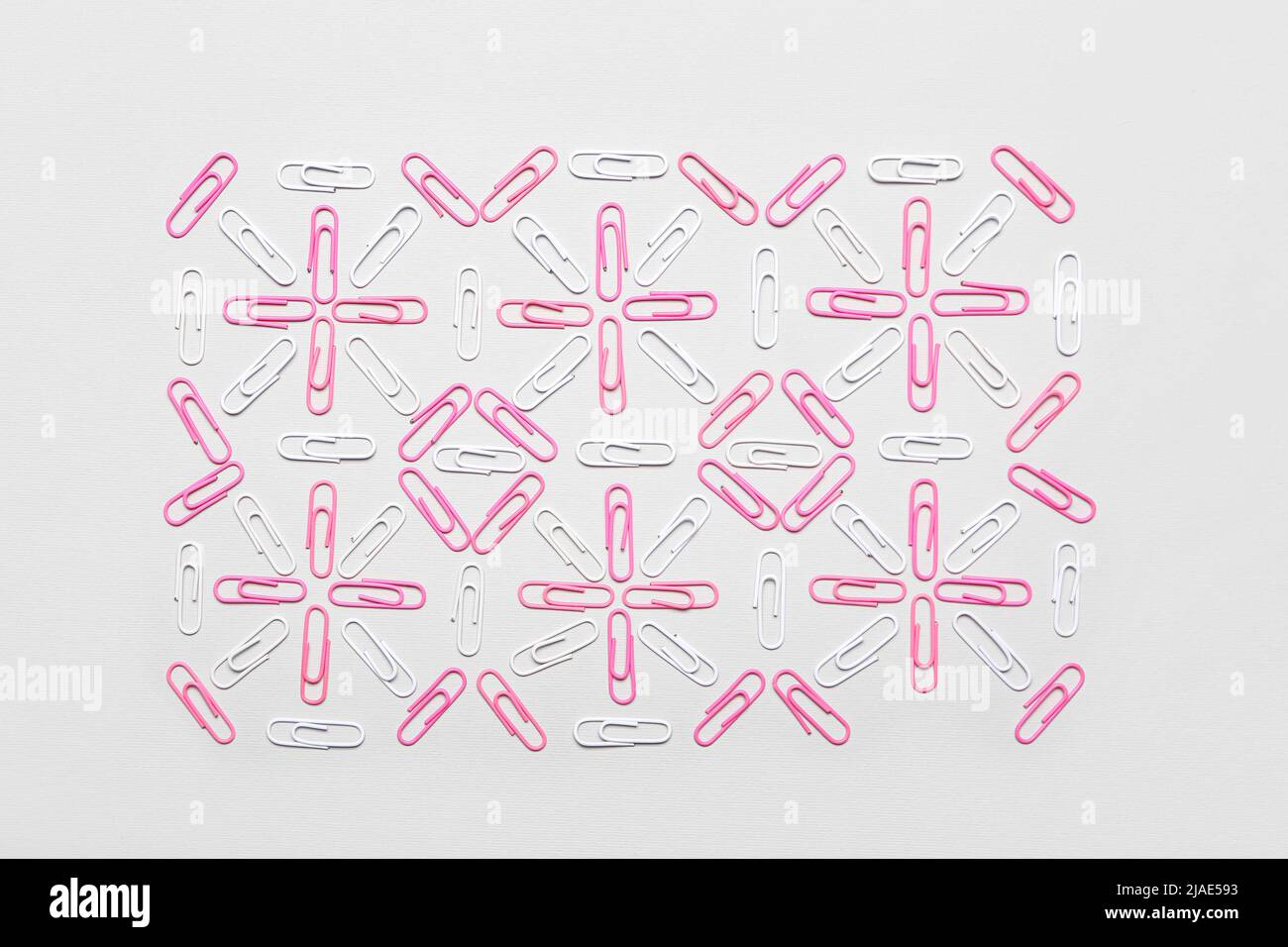 Pink and white paper clips on light background Stock Photo - Alamy