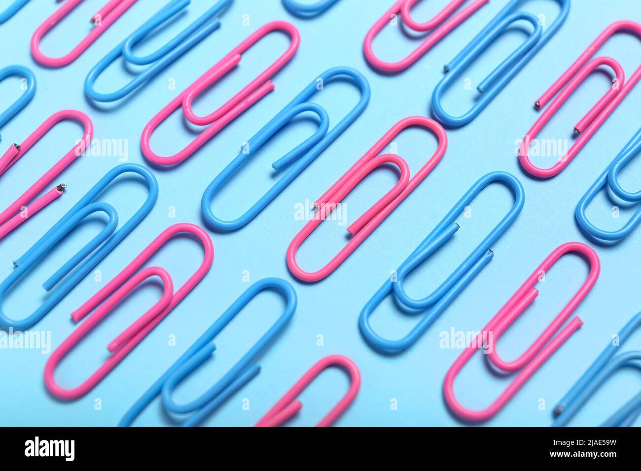 Pink and blue paper clips on color background, closeup Stock Photo - Alamy