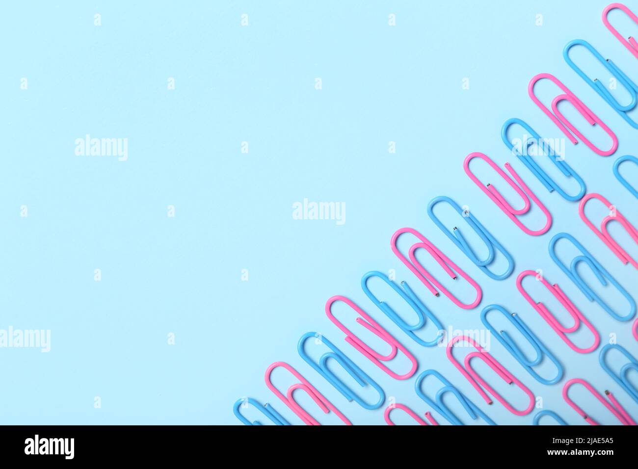 Pink and blue paper clips on color background Stock Photo - Alamy