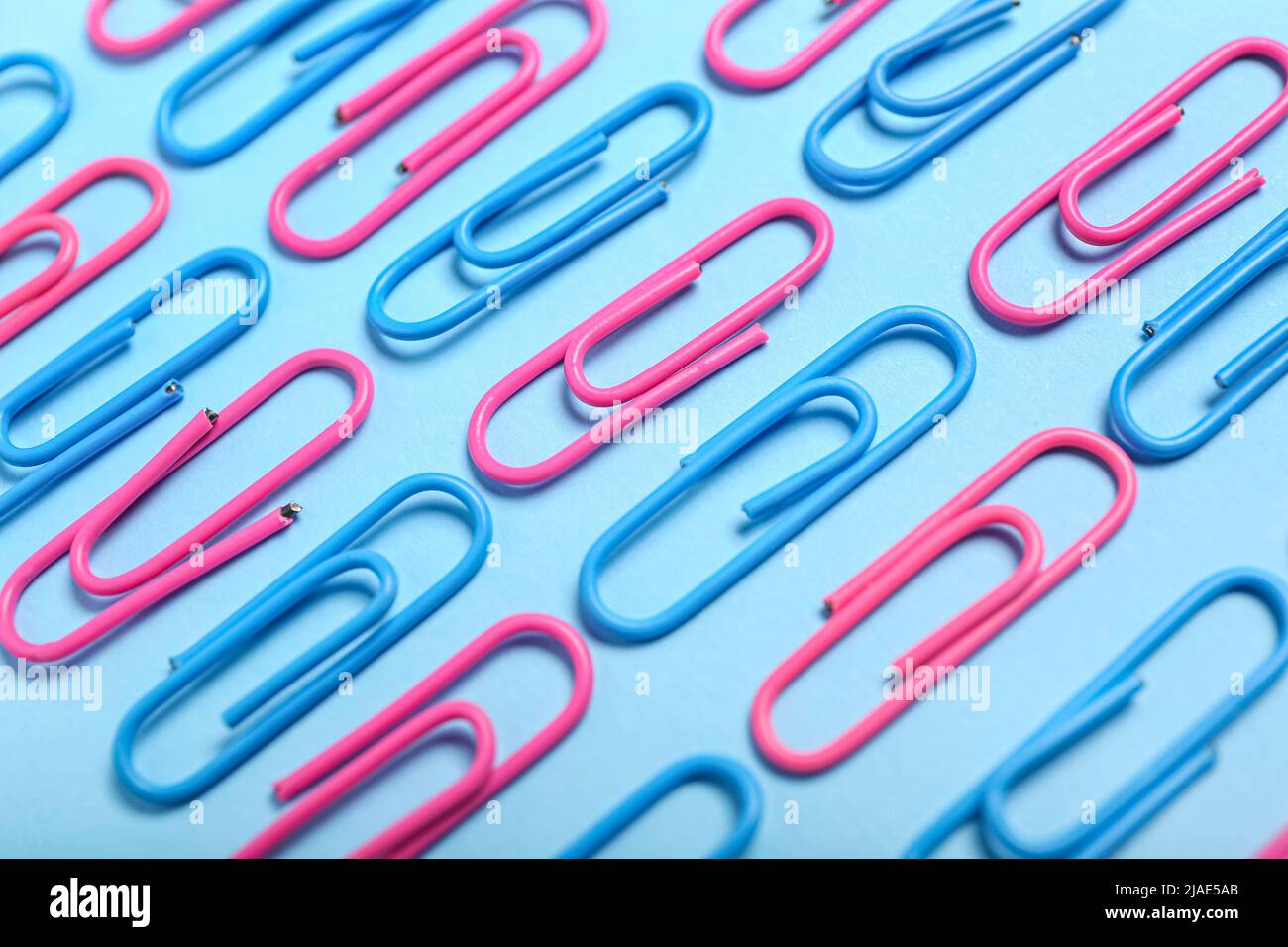 Pink and blue paper clips on color background, closeup Stock Photo - Alamy