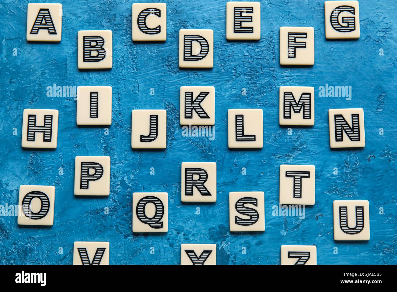 Different letters on blue background. Alphabet concept Stock Photo - Alamy