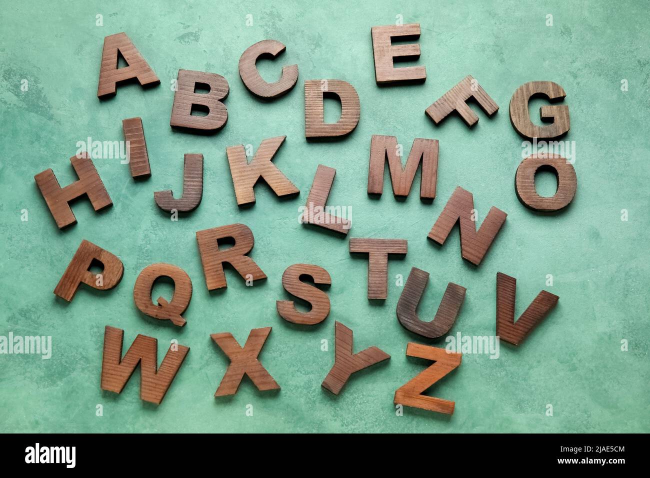 Wooden letters on green background. Alphabet concept Stock Photo - Alamy