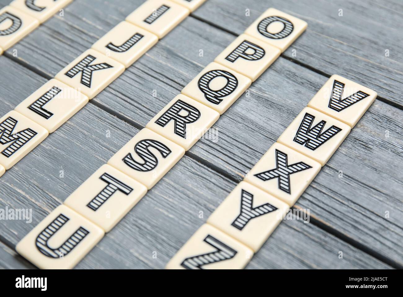 Different letters on grey wooden background. Alphabet concept Stock ...