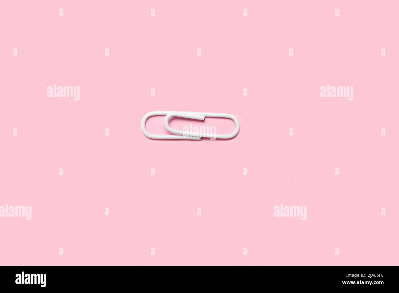 White paper clip on pink background Stock Photo - Alamy