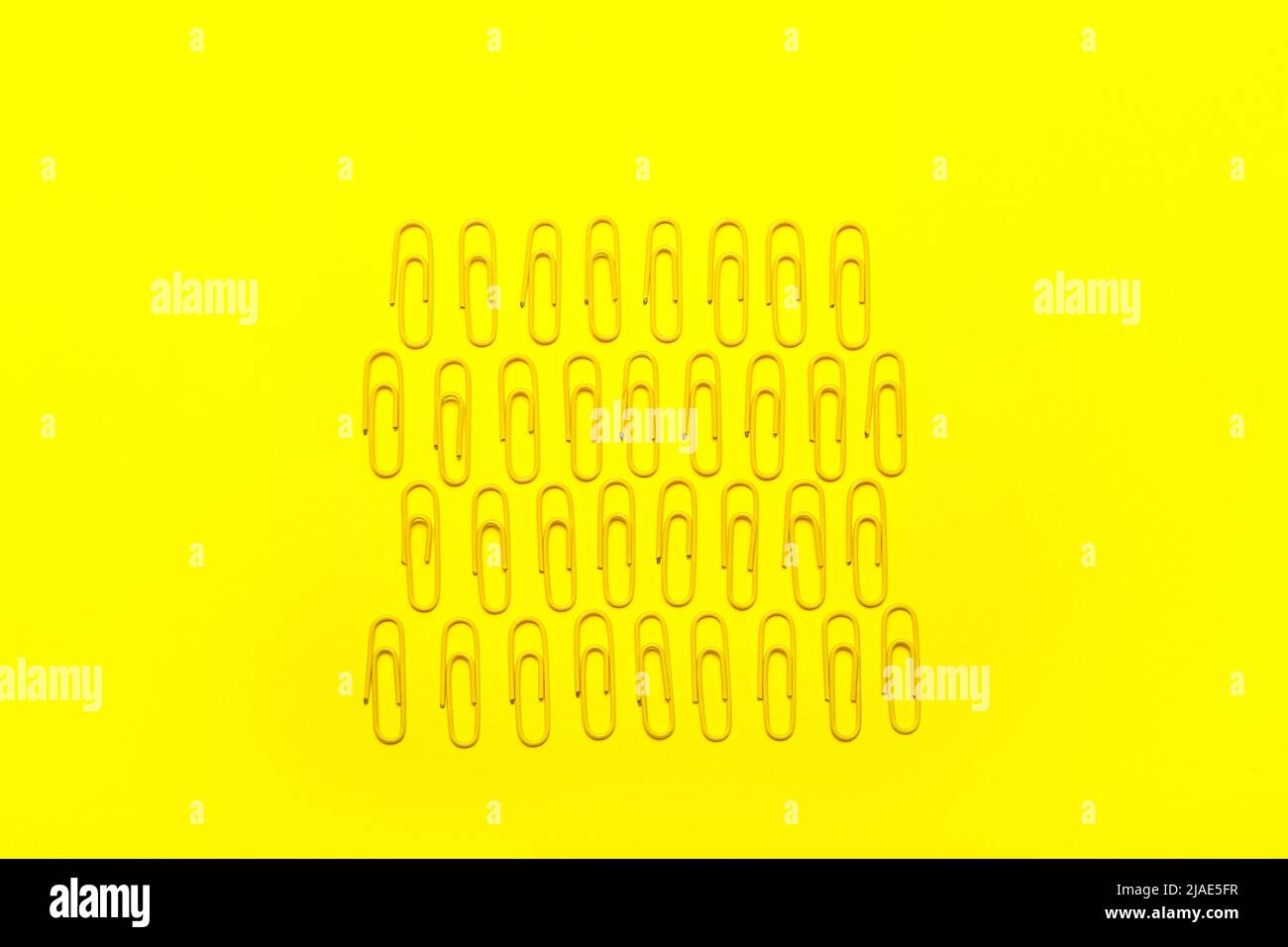 Yellow paper clips on color background Stock Photo - Alamy