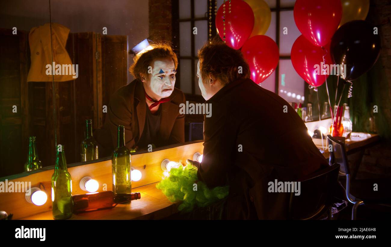 A sad man clown with white face crying in front of the mirror Stock ...