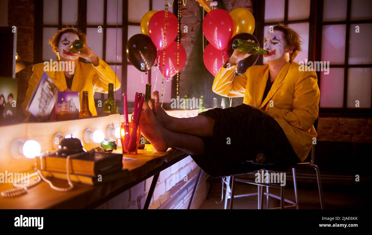 A depressed man clown drinking beer in the dressing room Stock Photo ...