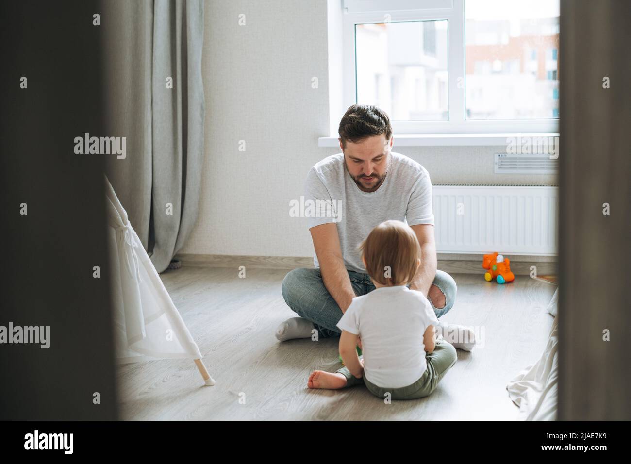 Happy father young man and baby girl little daughter having fun playing ...