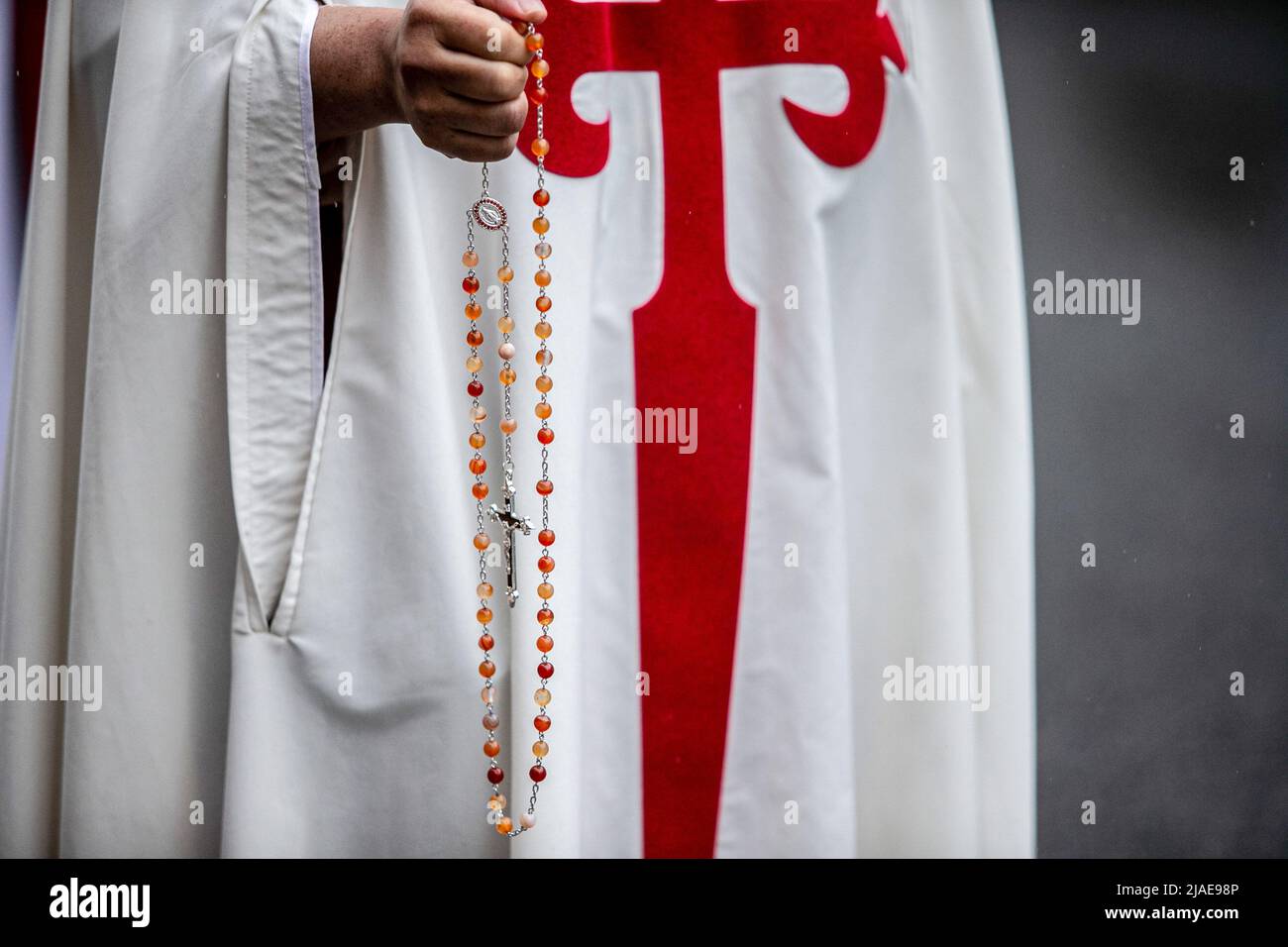 Detail of a rosary bead and the crucifix in contrast with a priest's ...
