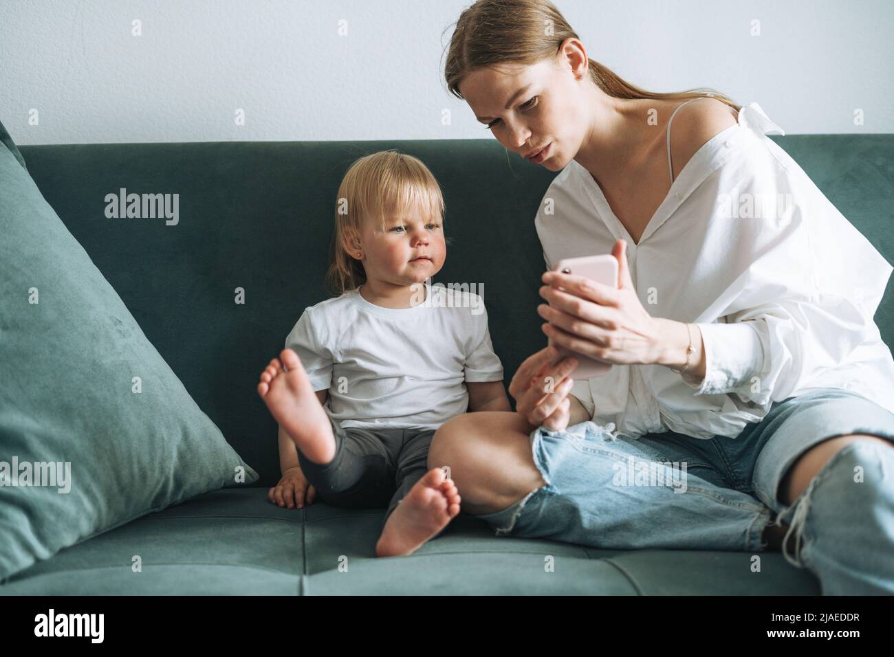 Young mother and cute baby girl using mobile phone at home Stock Photo ...