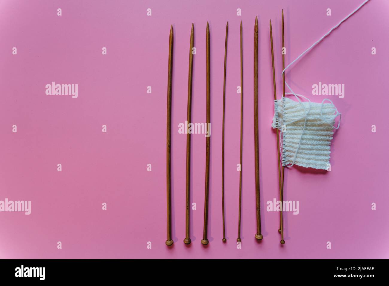 knitting needles on pink background Stock Photo - Alamy