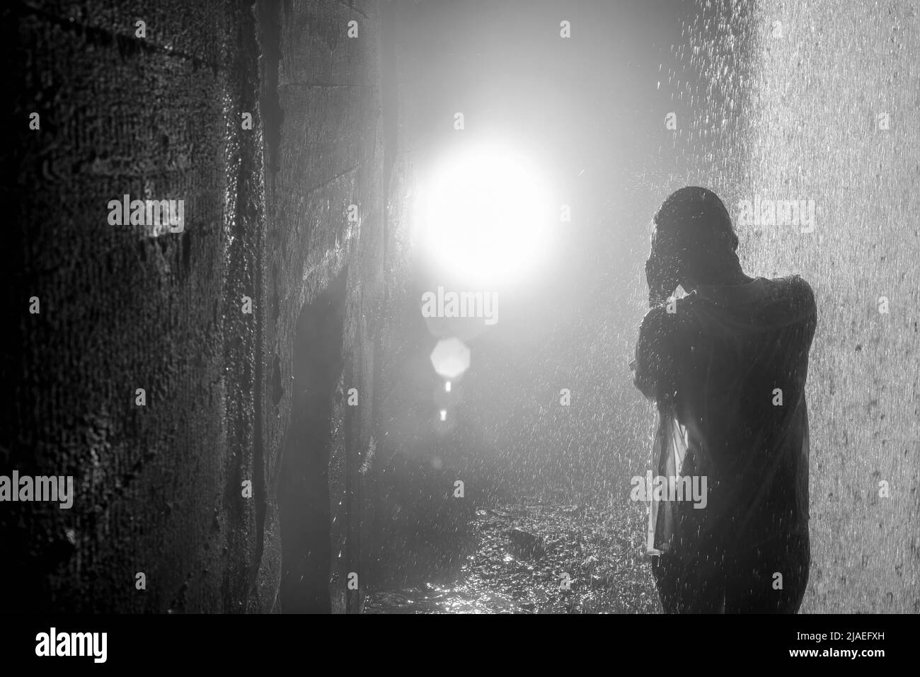 Young girl under jets of water into storm sewers Stock Photo - Alamy