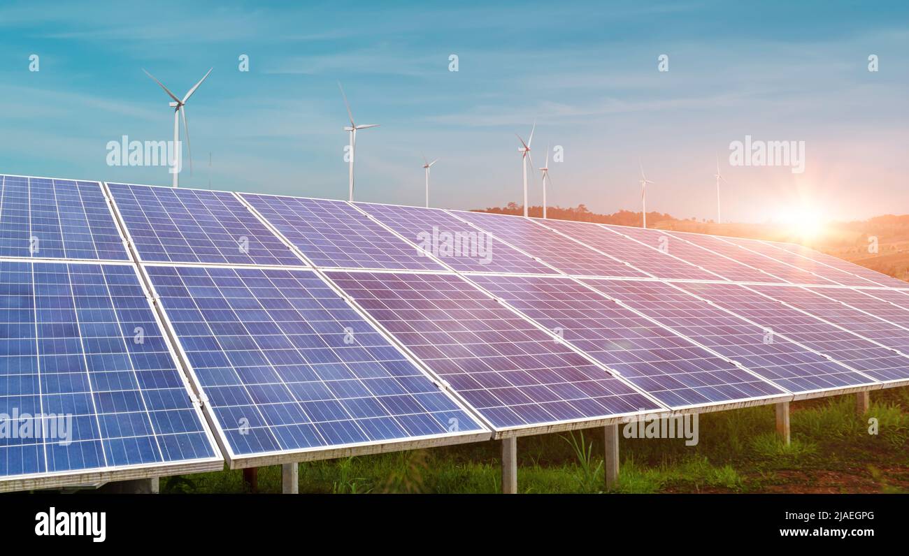 Solar panel and wind turbine field at sunset sky background ...