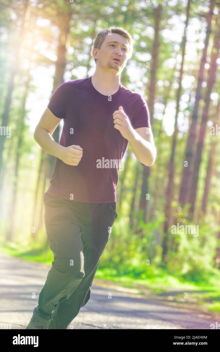 Running man jogging in city park at beautiful summer day. Sport fitness ...