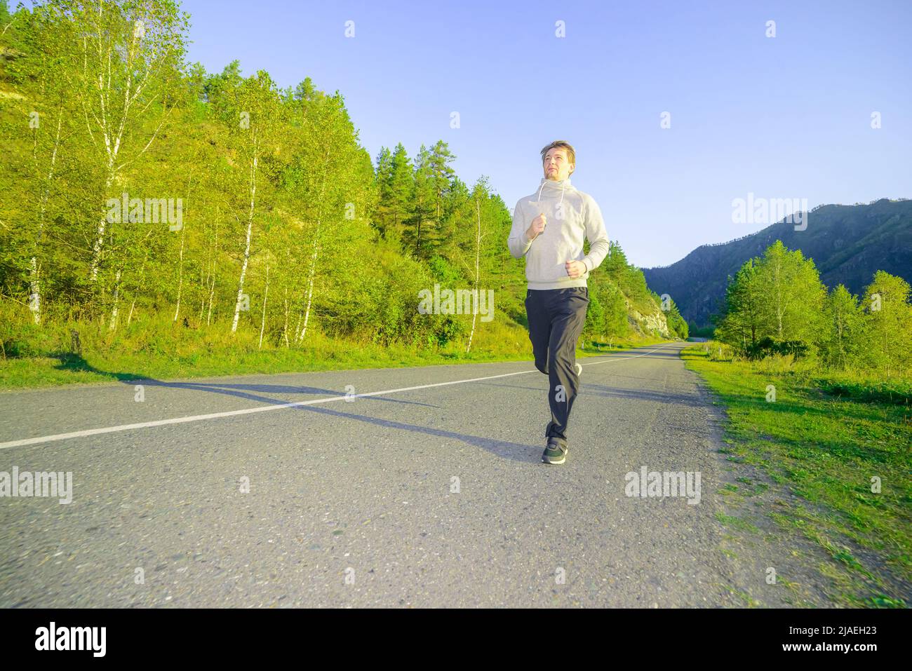 Running man jogging in city park at beautiful summer day. Sport fitness ...