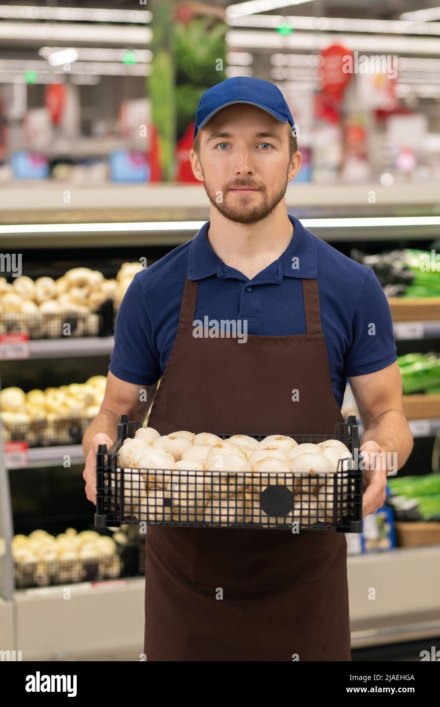 Vertical medium long shot of modern store worker wearing uniform ...